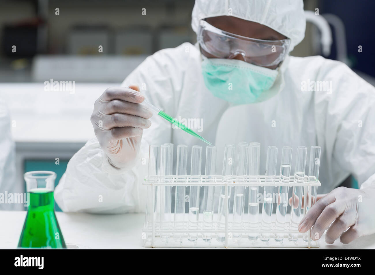 Chemist filling test tubes with green liquid Stock Photo - Alamy