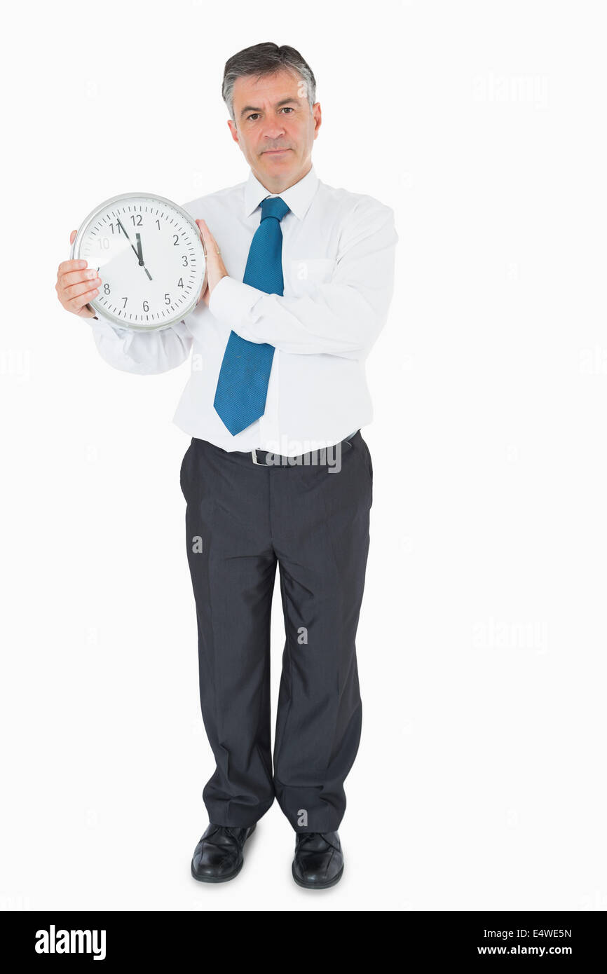 Serious businessman holding clock Stock Photo - Alamy