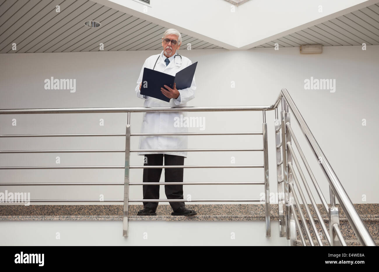 Doctor reading patient files Stock Photo - Alamy