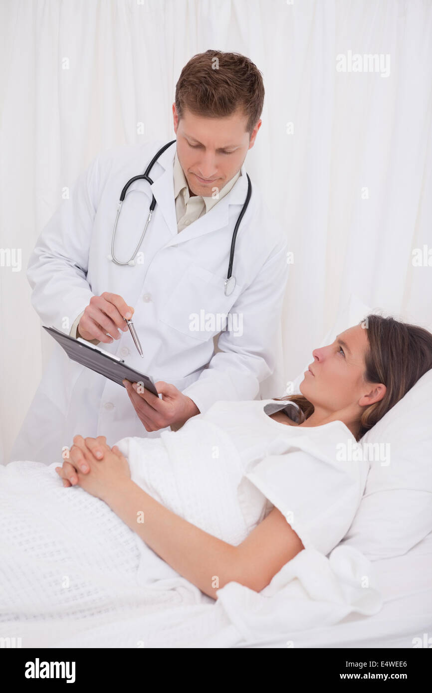 Standing doctor talking with patient Stock Photo - Alamy