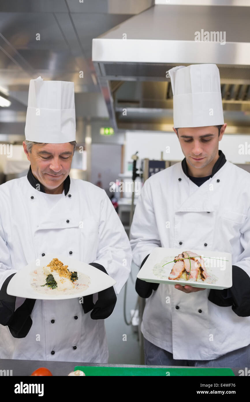 Two cooks proudly presenting their meals Stock Photo - Alamy