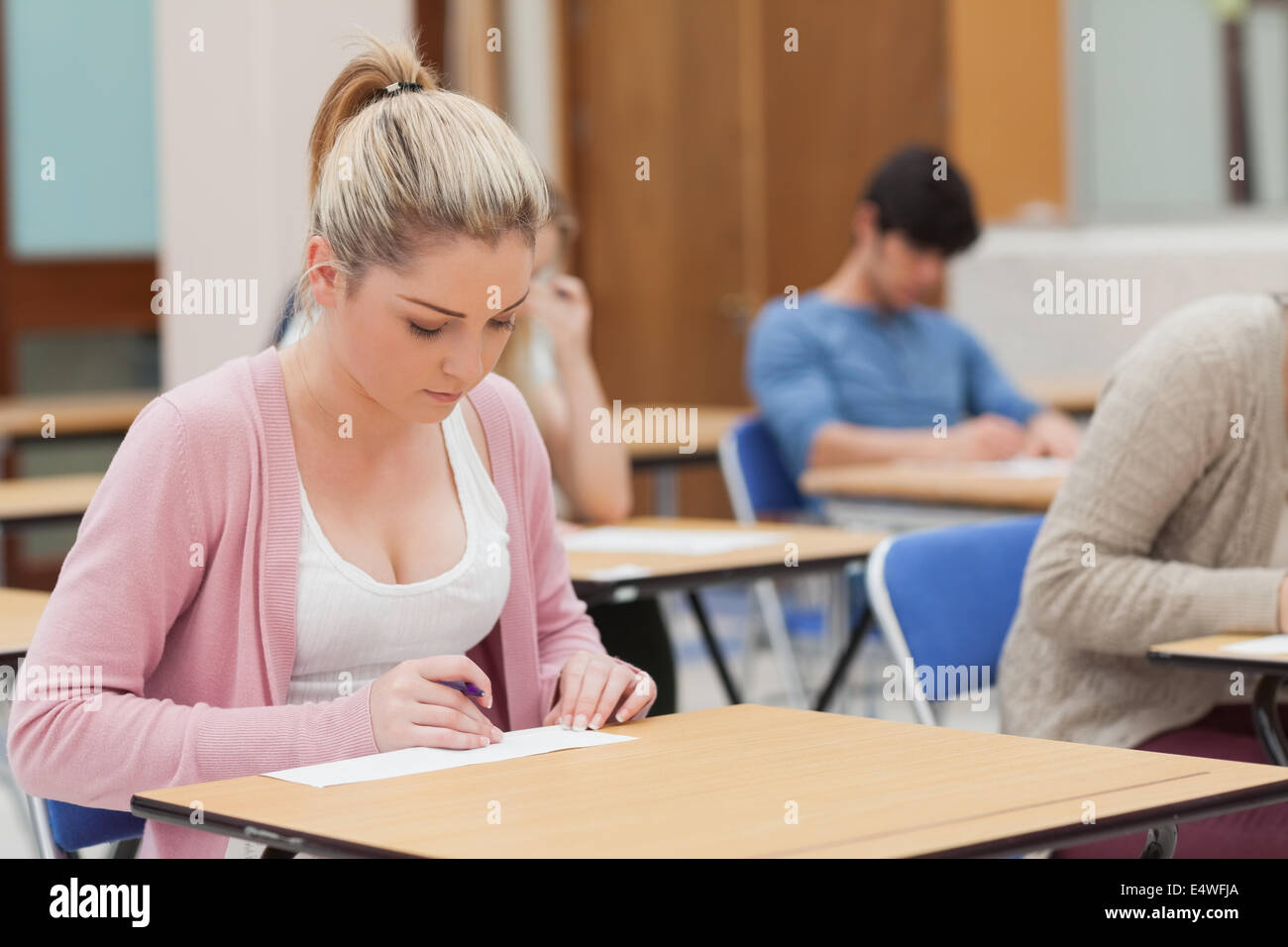 Woman writing note in classroom Stock Photo - Alamy