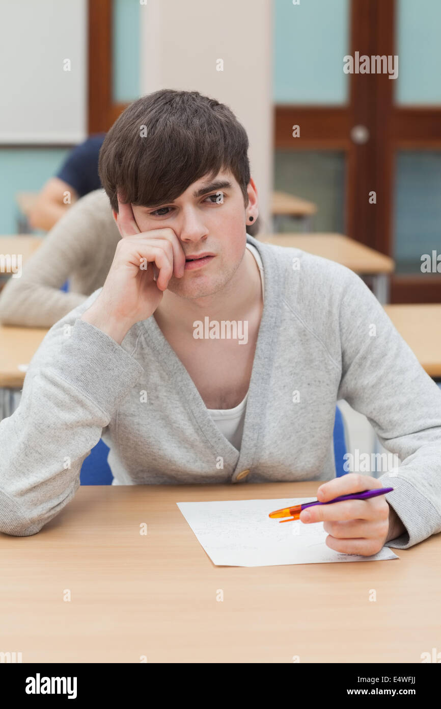 Student sitting at table thinking Stock Photo - Alamy