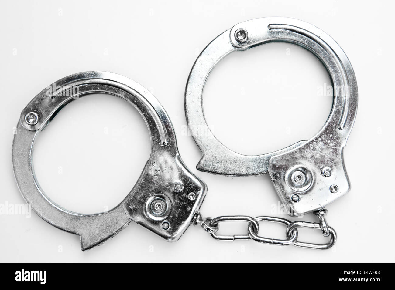 Handcuffs against white background Stock Photo - Alamy
