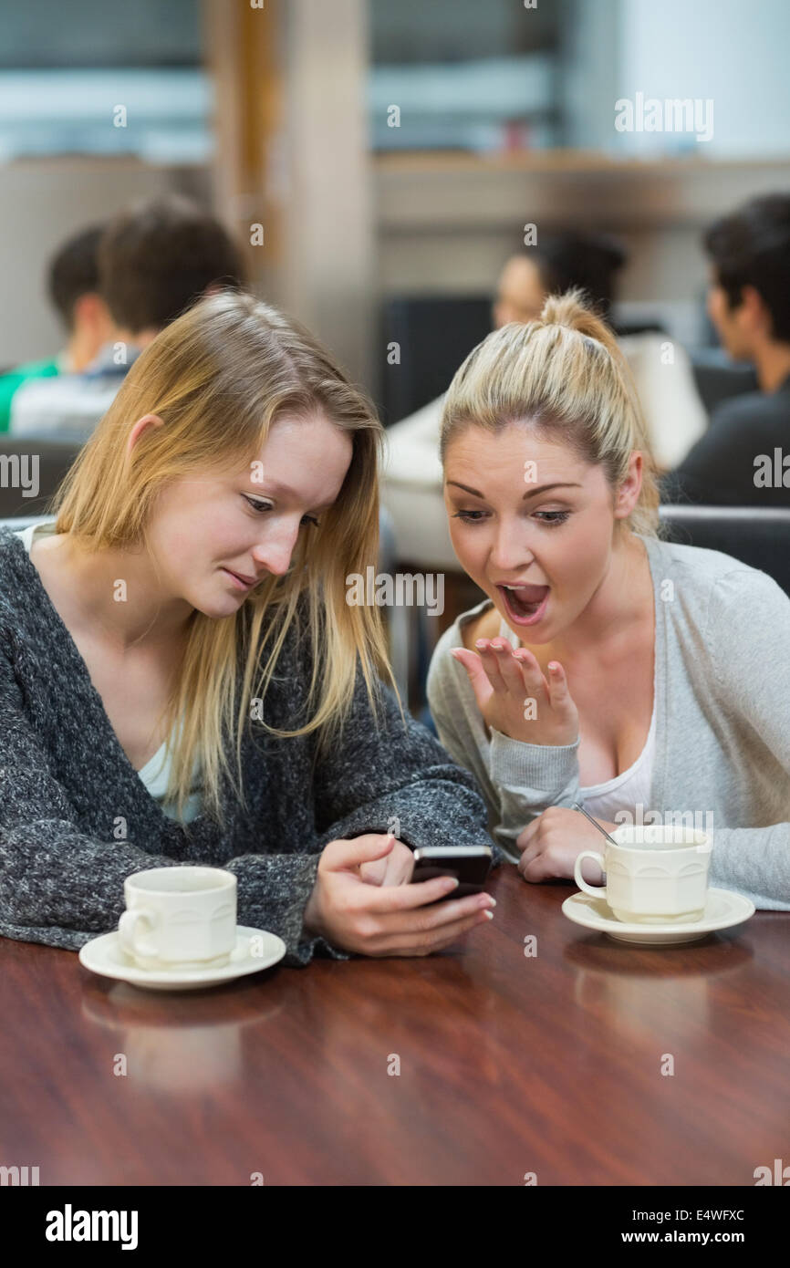 Student showing friend shocking text message Stock Photo - Alamy