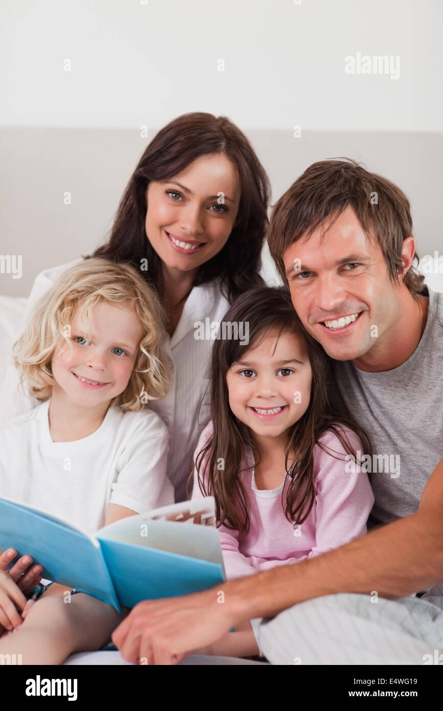 Portrait of a happy family reading a book Stock Photo - Alamy
