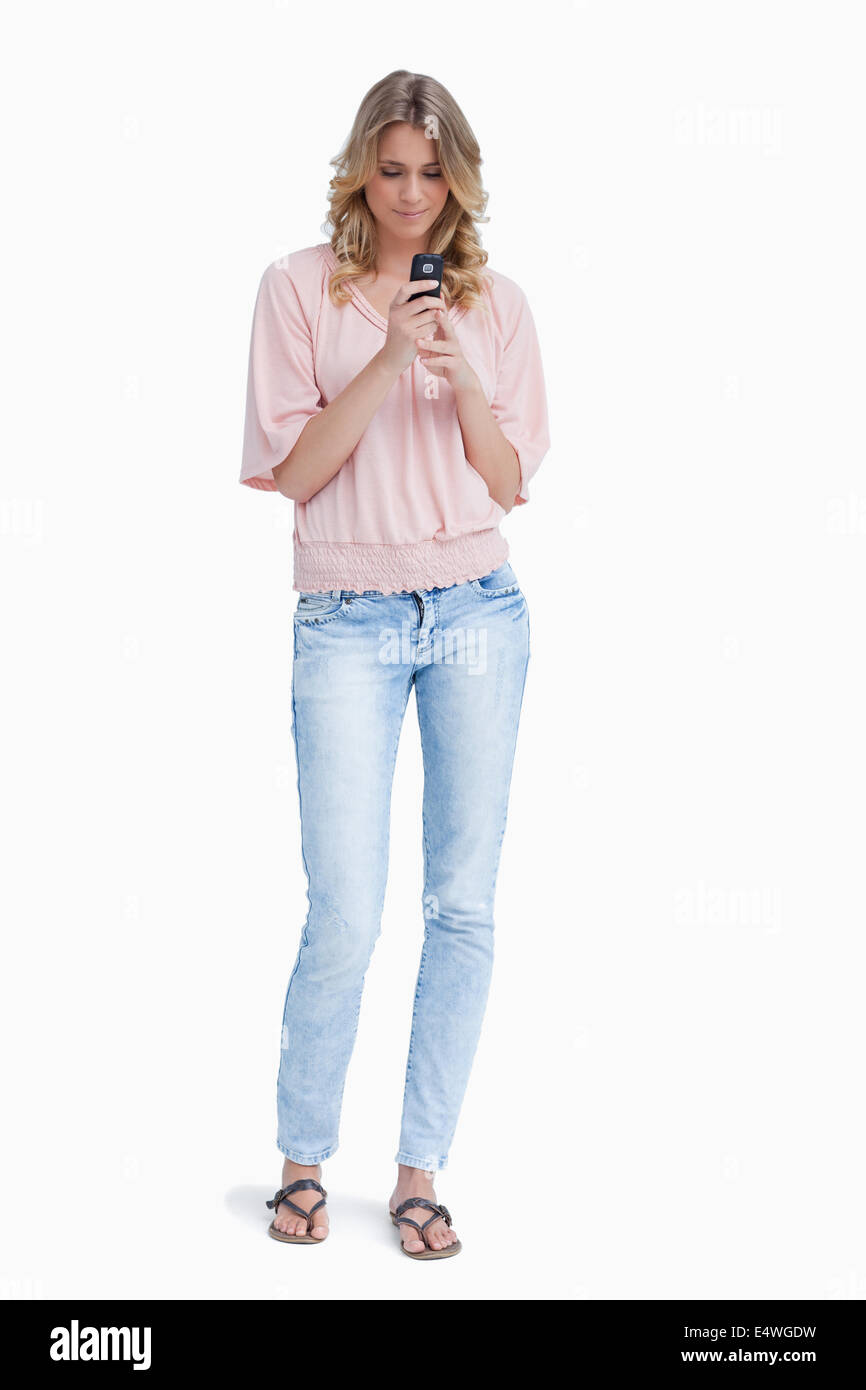 A woman standing holding her mobile phone Stock Photo - Alamy