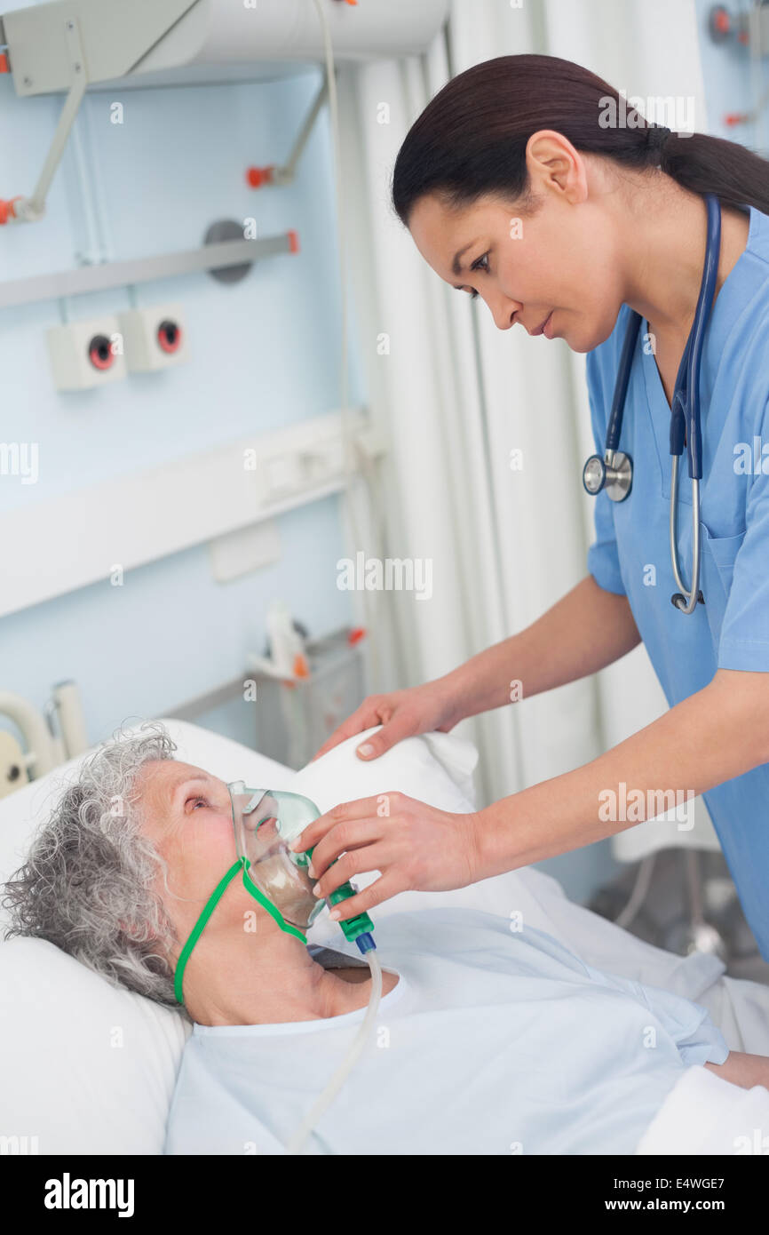 Nurse putting oxygen mask on a patient Stock Photo - Alamy