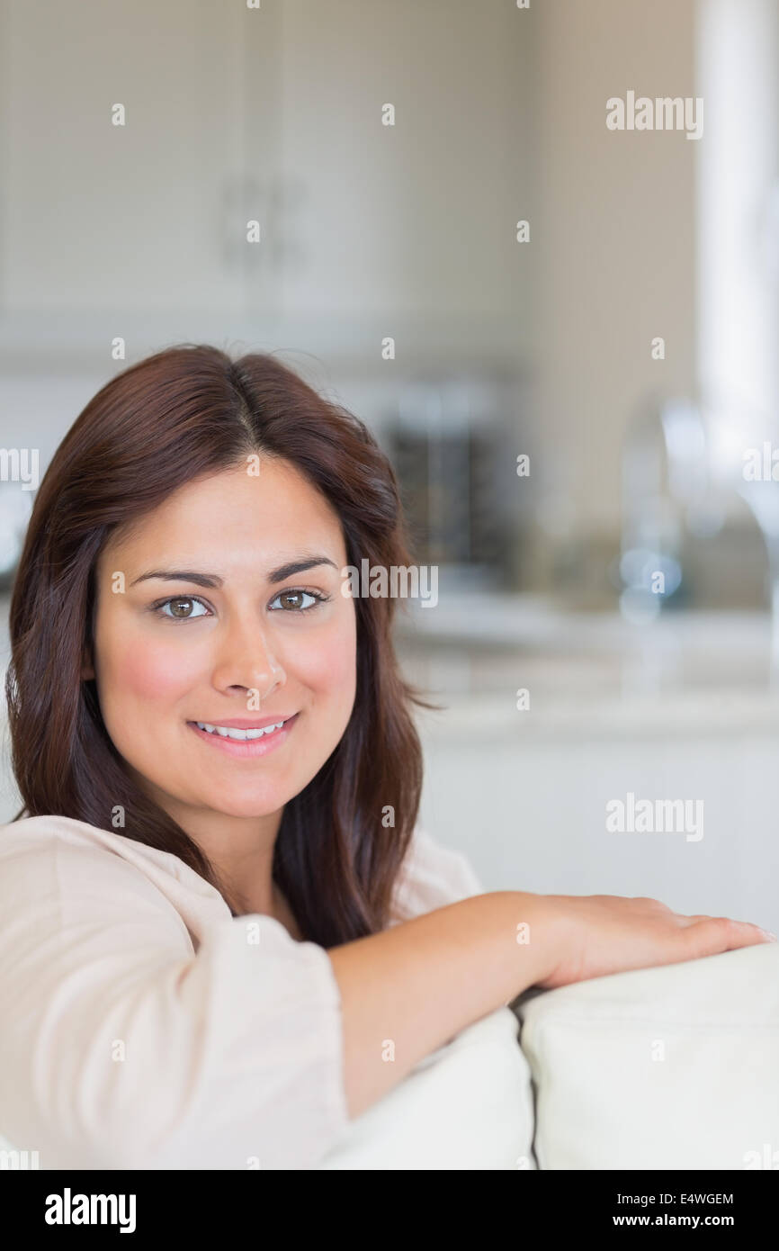 Smiling woman sitting on sofa Stock Photo - Alamy