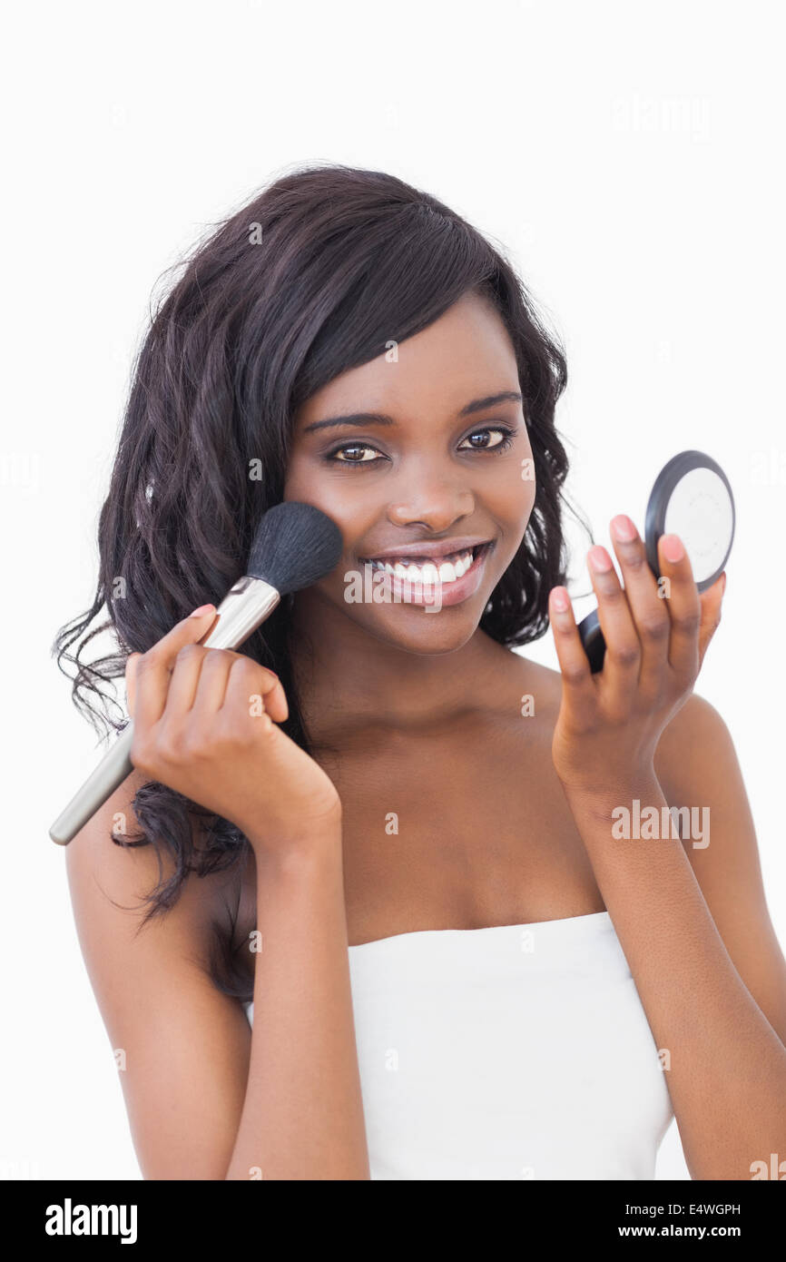 Woman smiling while holding powder compact Stock Photo - Alamy