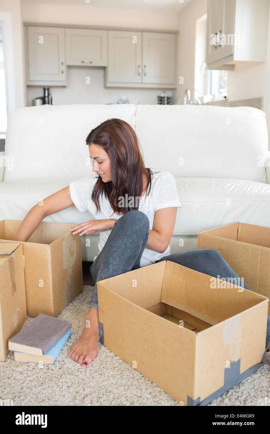 Woman happily unpacking moving boxes Stock Photo - Alamy