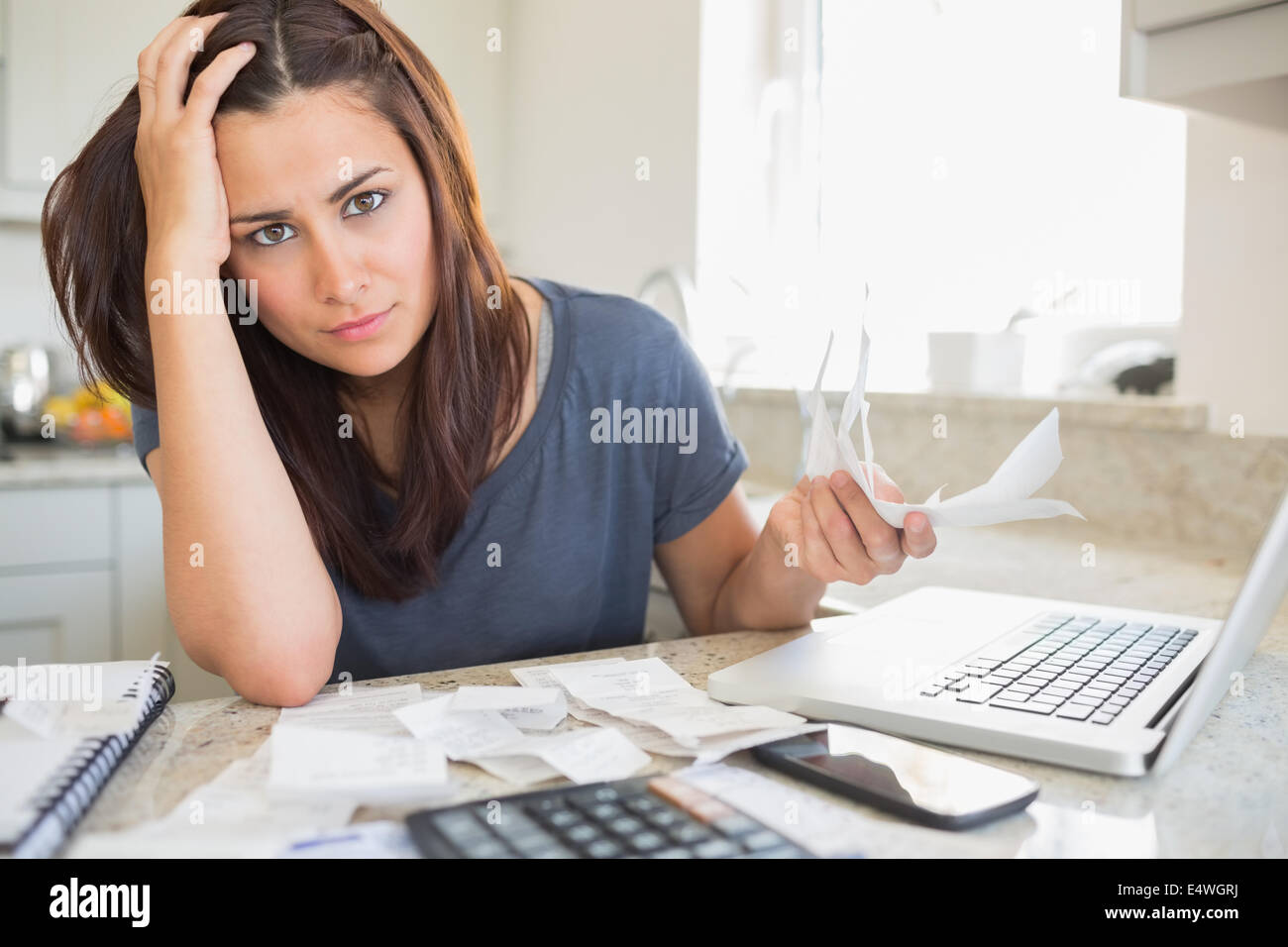 Young woman looking worried over finances Stock Photo - Alamy