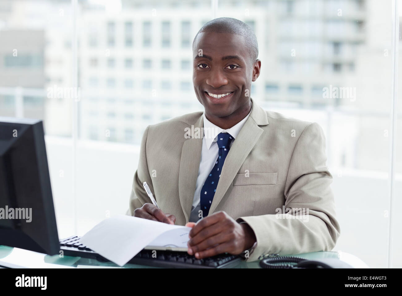 Smiling entrepreneur signing a document Stock Photo - Alamy
