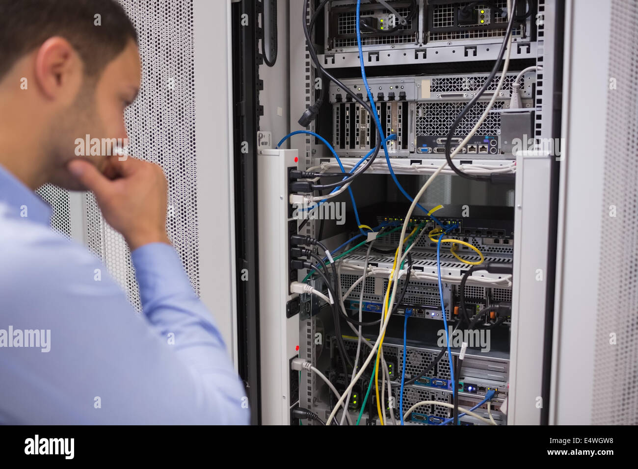 Man looking at rack mounted servers Stock Photo - Alamy