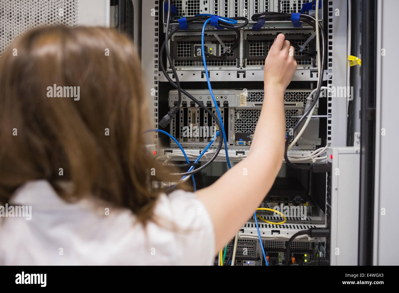 Woman fixing wires of servers Stock Photo - Alamy
