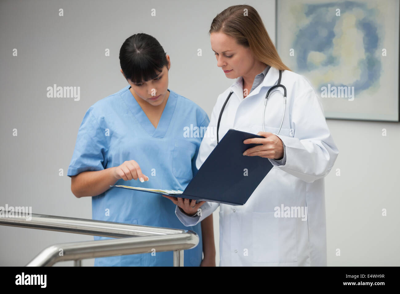 Female doctor explaining notes to nurse Stock Photo - Alamy