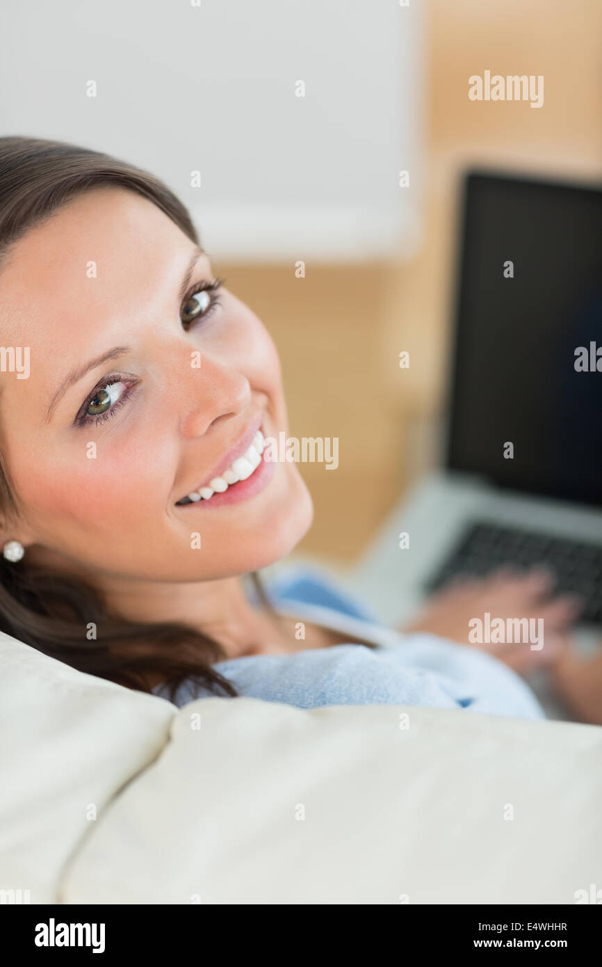 Happy woman using laptop on sofa Stock Photo - Alamy