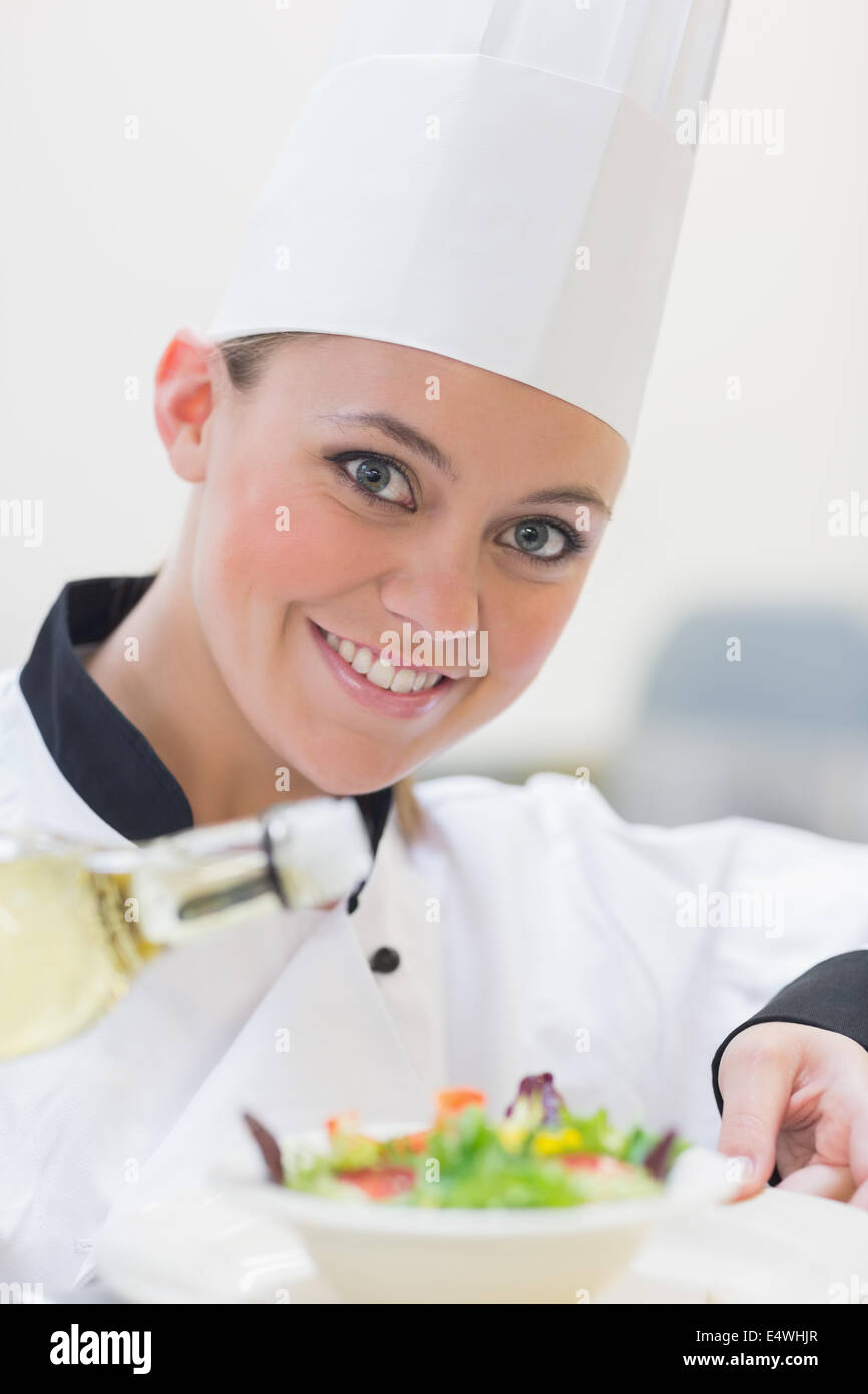 Smiling chef dressing a salad Stock Photo - Alamy