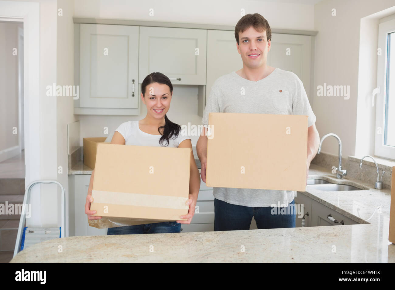 Young man and woman holding moving boxes Stock Photo - Alamy
