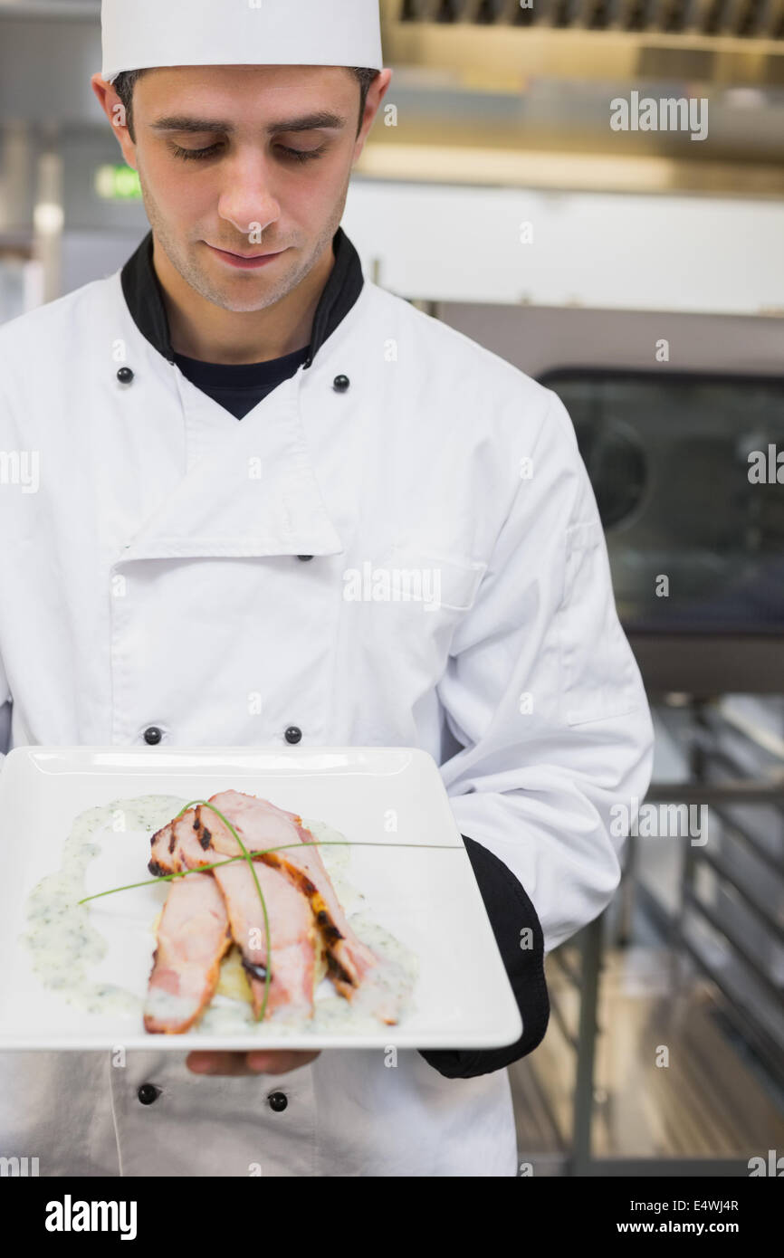 Chef looking down at his chicken dish Stock Photo - Alamy