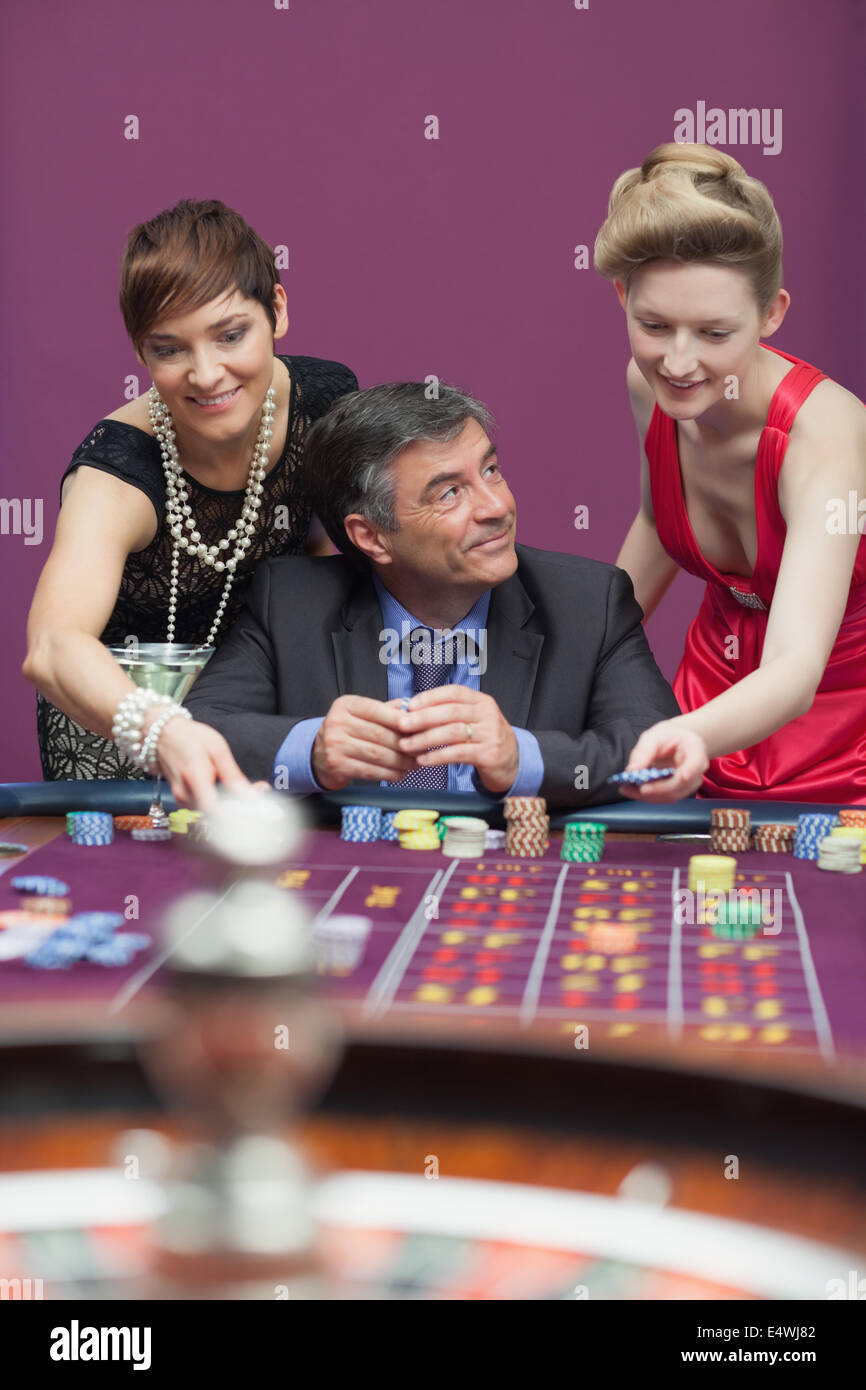 Woman placing bet for man at roulette Stock Photo - Alamy