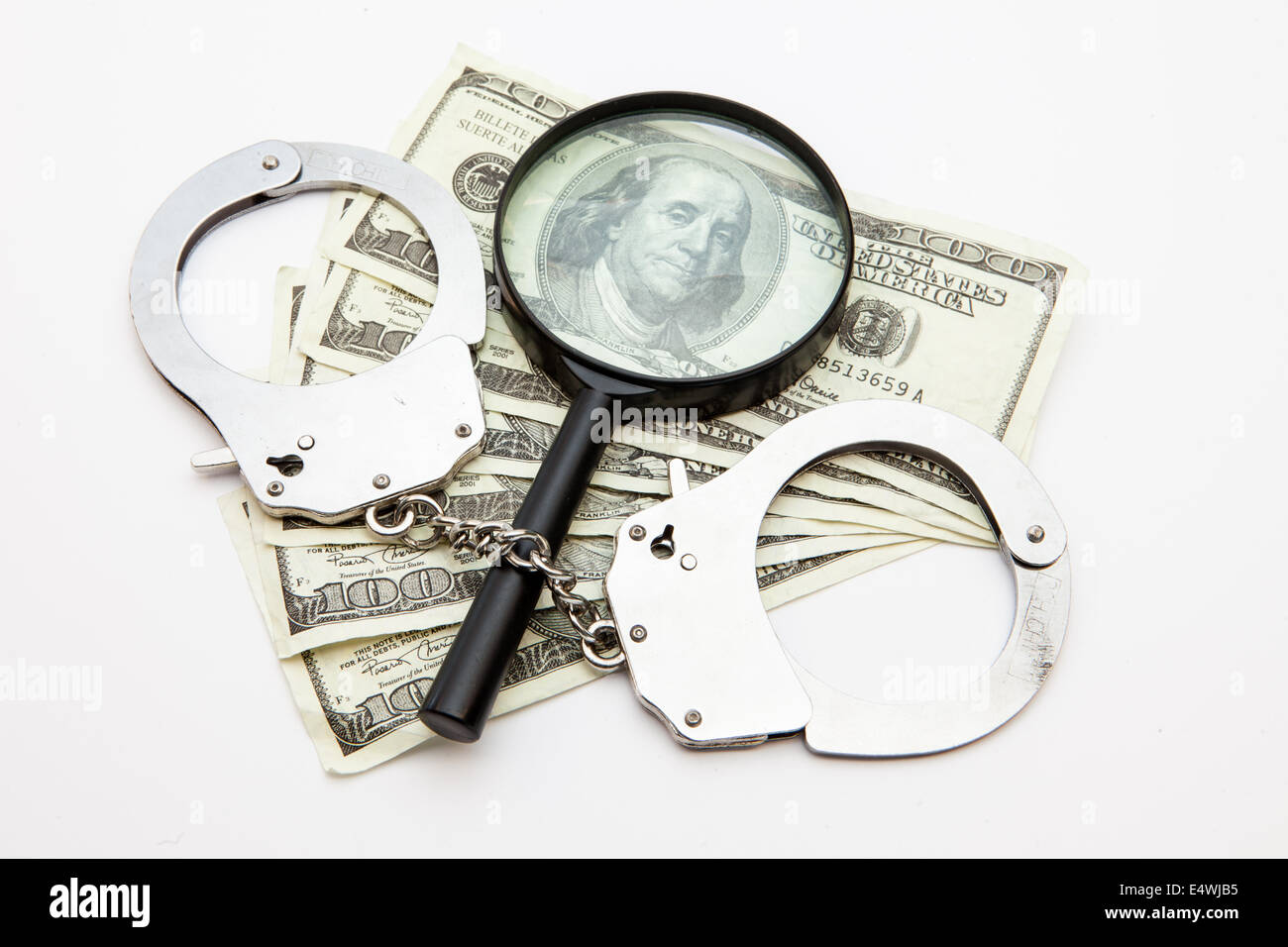 Magnifying glass money and handcuffs Stock Photo - Alamy