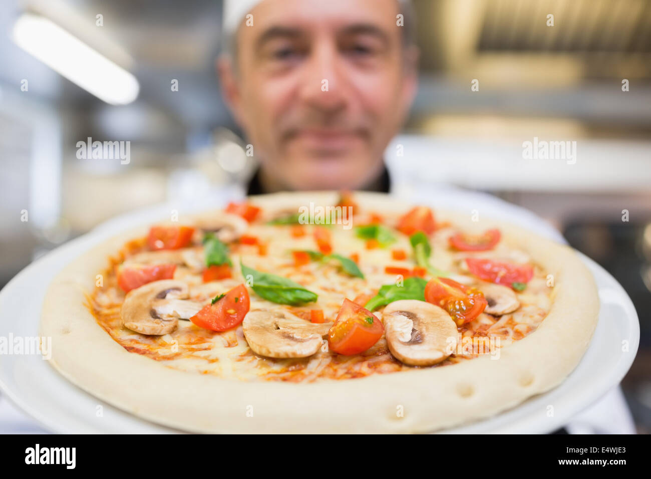 Chef holding pizza up Stock Photo - Alamy
