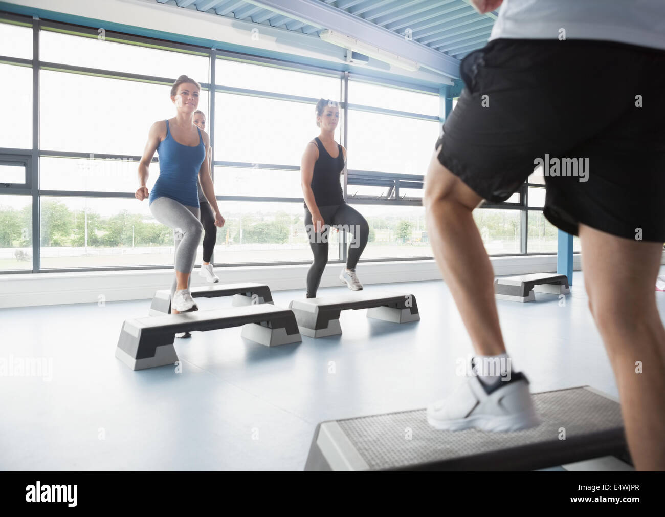 Trainer stepping with aerobic class Stock Photo - Alamy