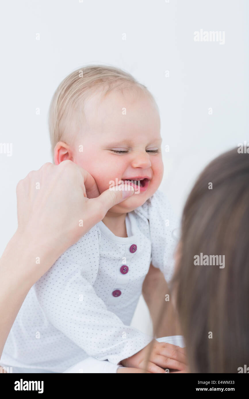 Mother touching the cheek of a baby Stock Photo - Alamy