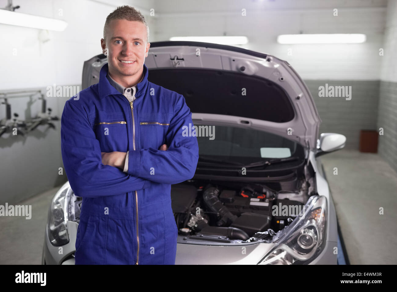 Mechanic standing with arms crossed Stock Photo - Alamy
