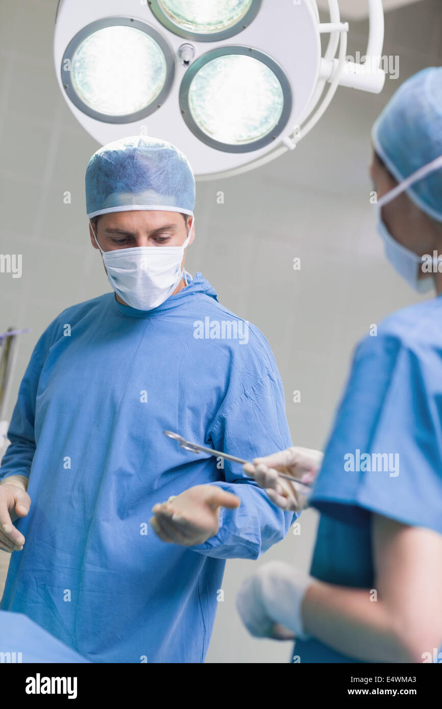 Nurse giving surgical scissors to a doctor Stock Photo - Alamy