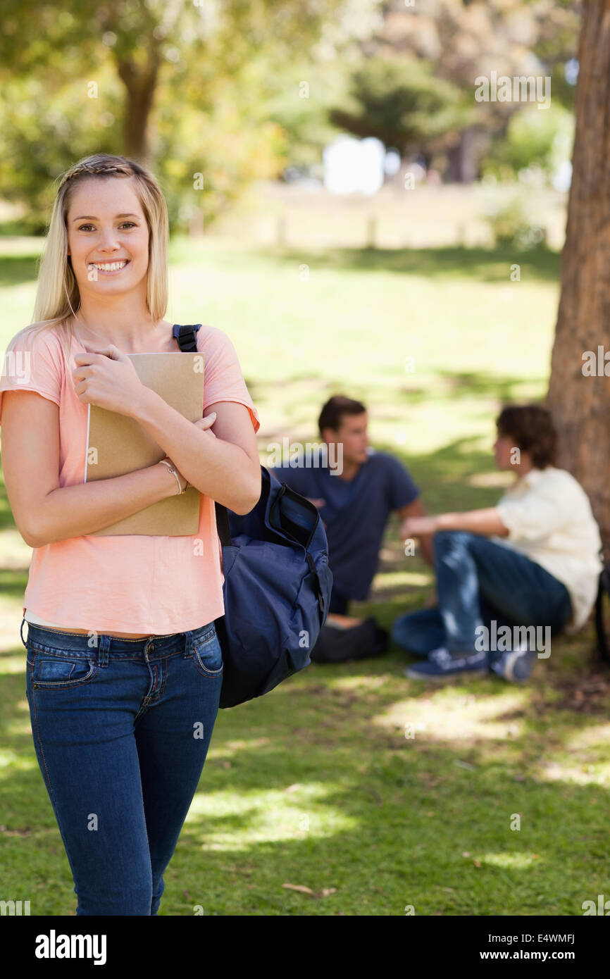 Smiling female holding a textbook Stock Photo - Alamy