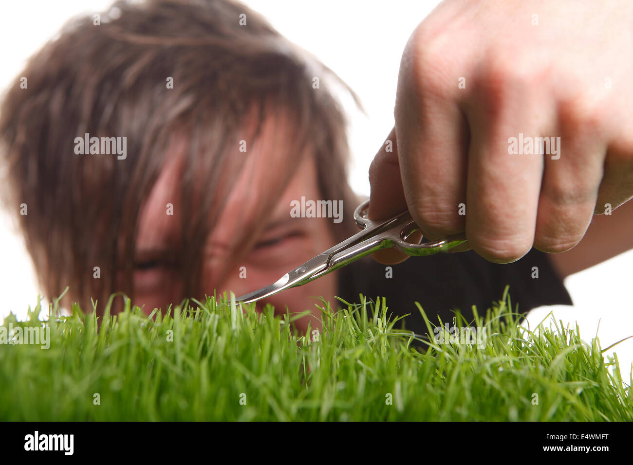 Young man cuts English lawn with a nail scissors Stock Photo - Alamy