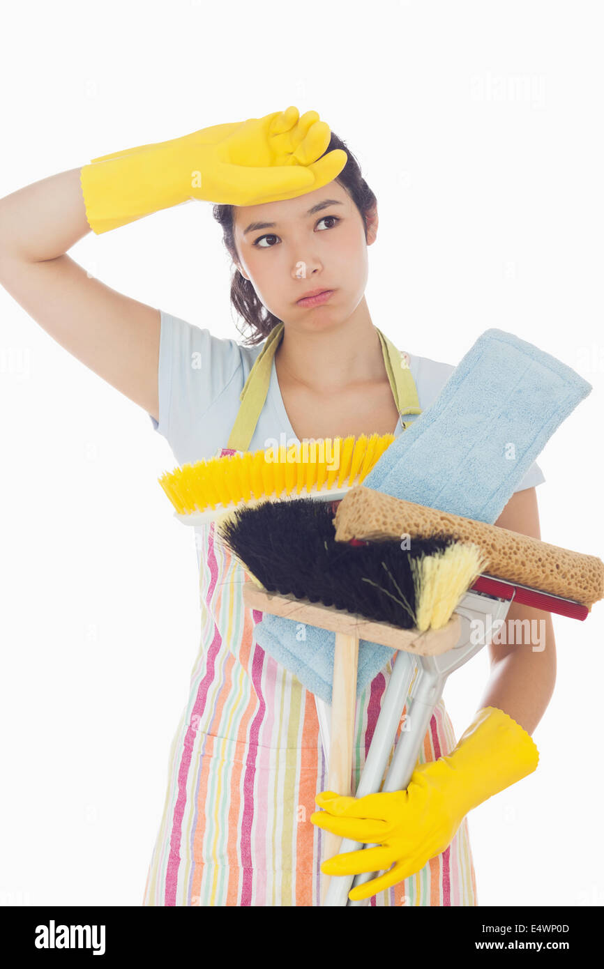 Overworked woman holding cleaning tools Stock Photo - Alamy