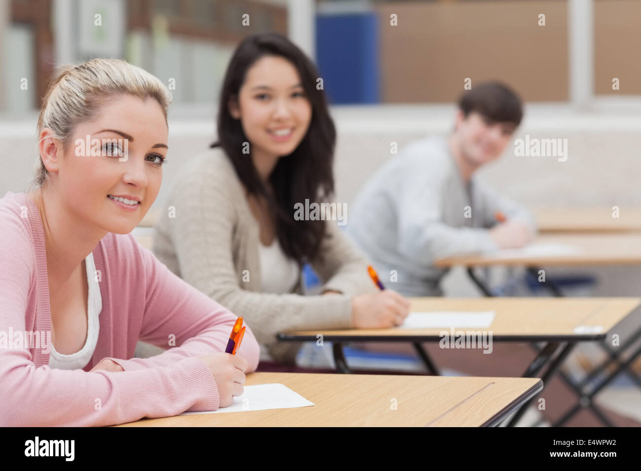 Students looking up from exam and smiling Stock Photo - Alamy