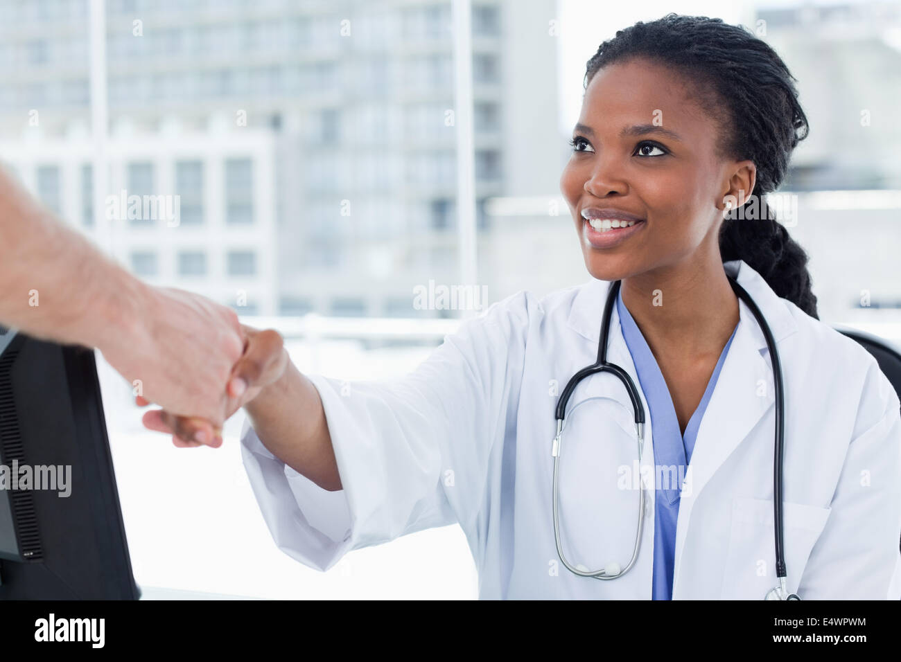 Female doctor shaking a hand Stock Photo - Alamy