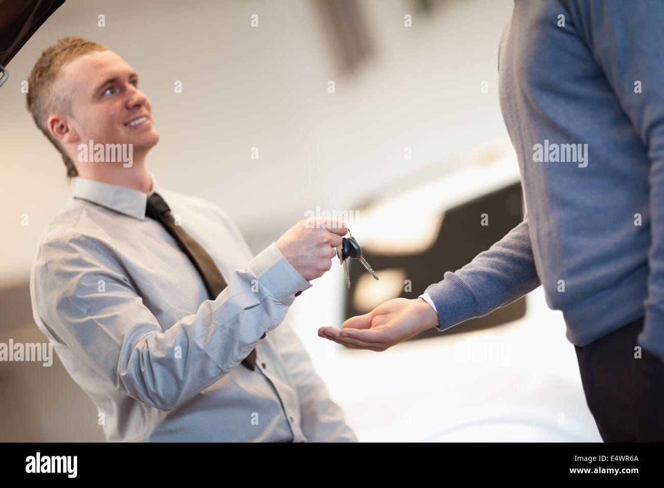 Smiling man giving keys to a man Stock Photo - Alamy