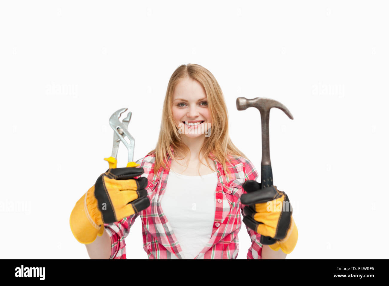 Woman holding tools while smiling Stock Photo - Alamy