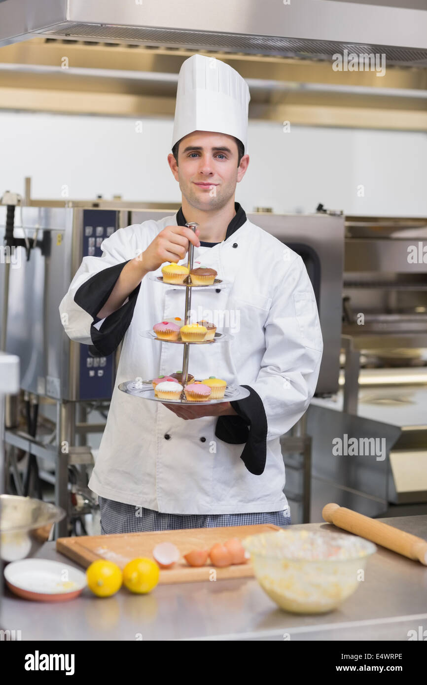 Pastry chef holding tiered cake tray Stock Photo - Alamy