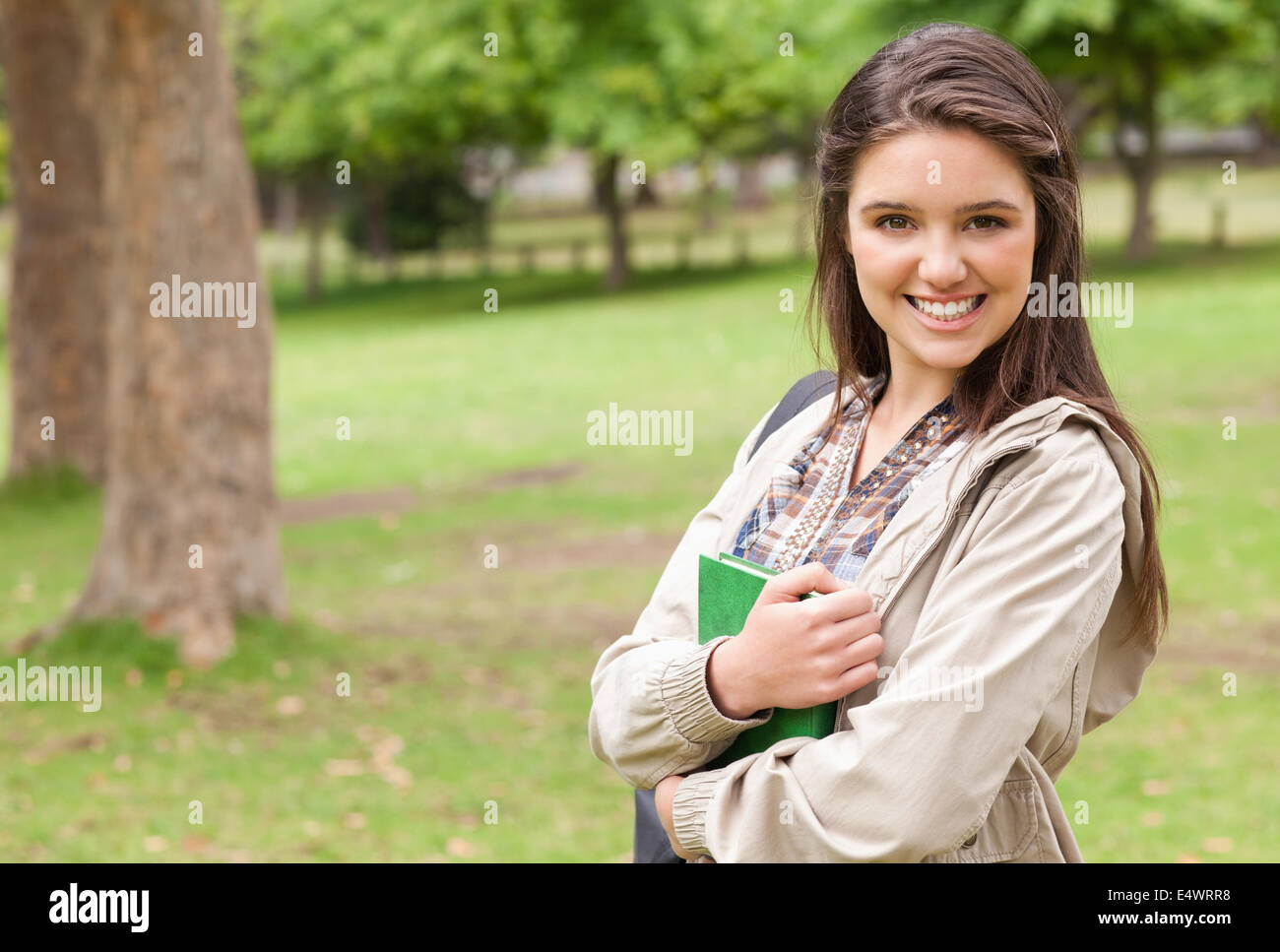 Portrait of a young student holding textbook Stock Photo - Alamy