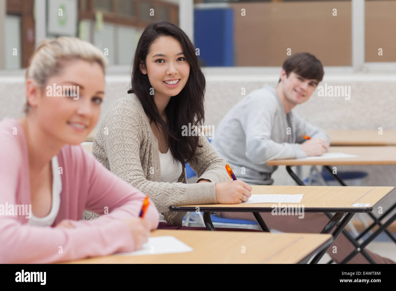 Happy students looking up from doing exam Stock Photo - Alamy