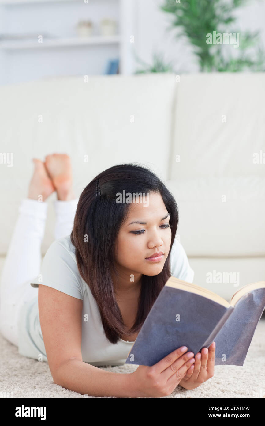Woman lying on the floor reading a book Stock Photo - Alamy