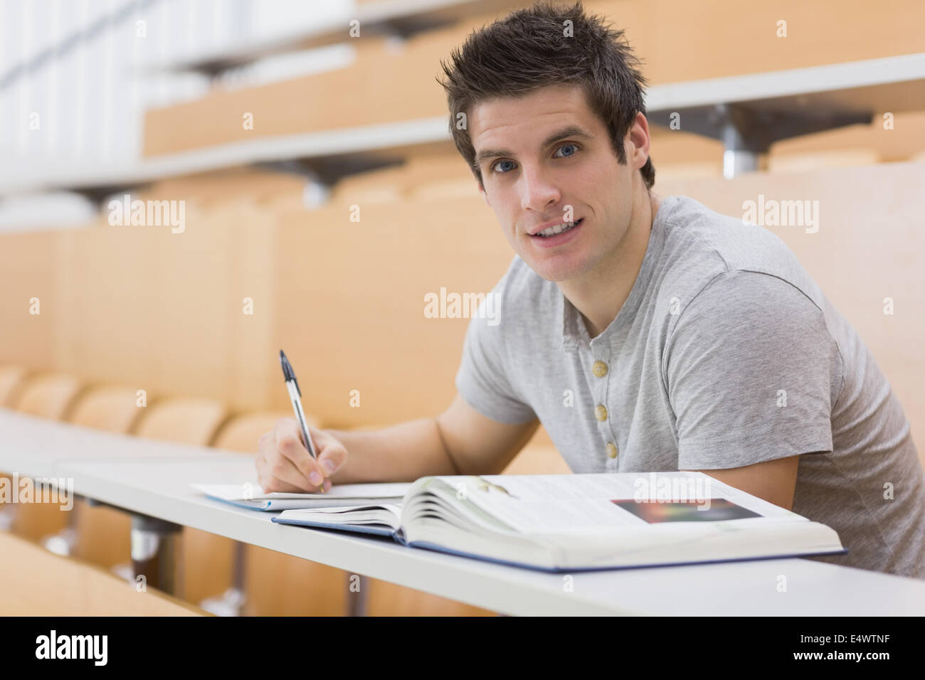 Student sitting at the desk smiling Stock Photo - Alamy