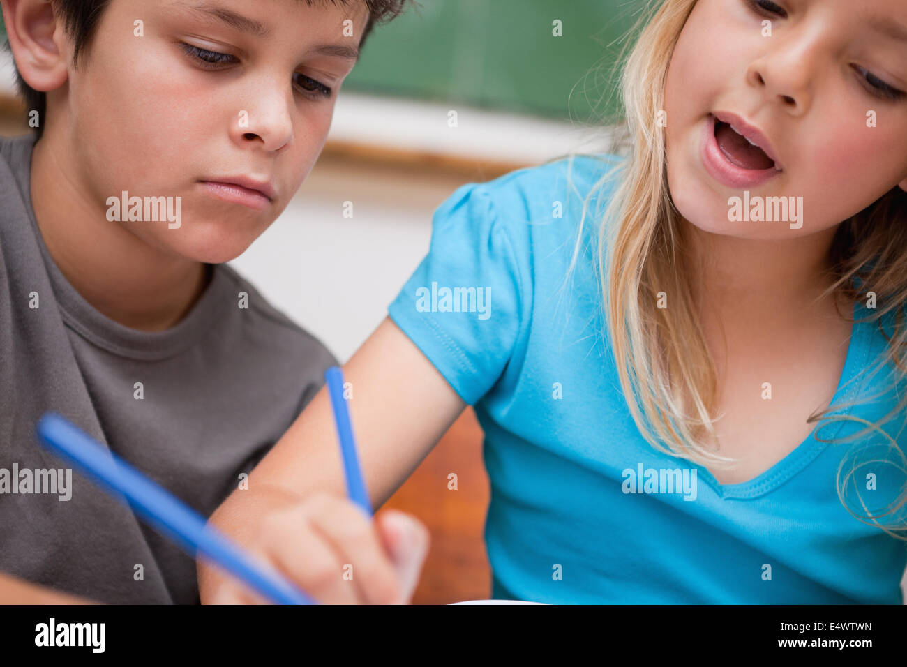 Close up of two children writing Stock Photo - Alamy