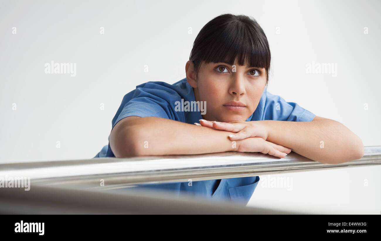 Nurse leaning against rail Stock Photo - Alamy