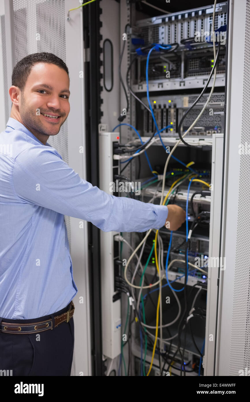 Smiling man adjusting server Stock Photo - Alamy