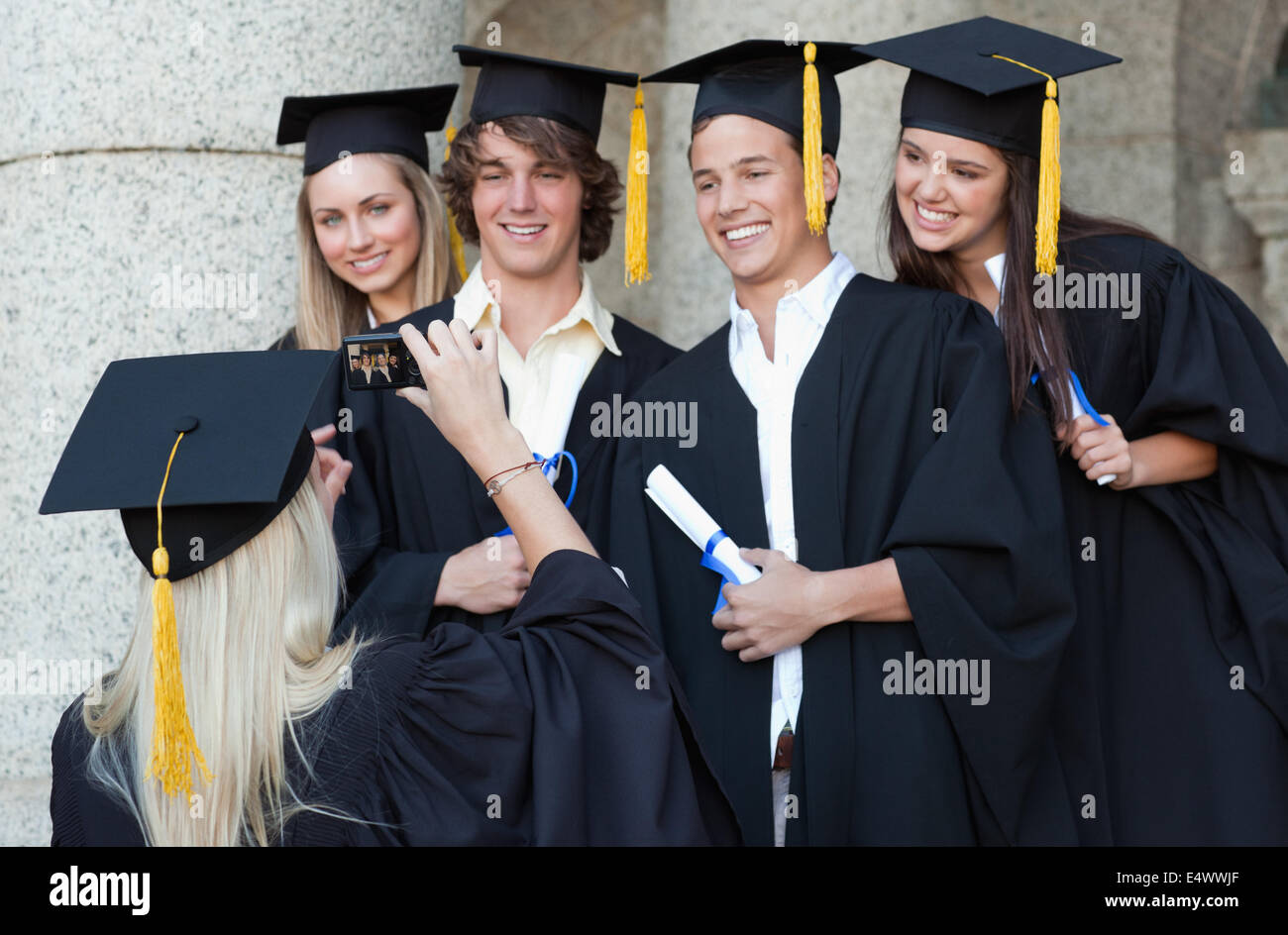 Graduate taking a picture of her friend Stock Photo - Alamy