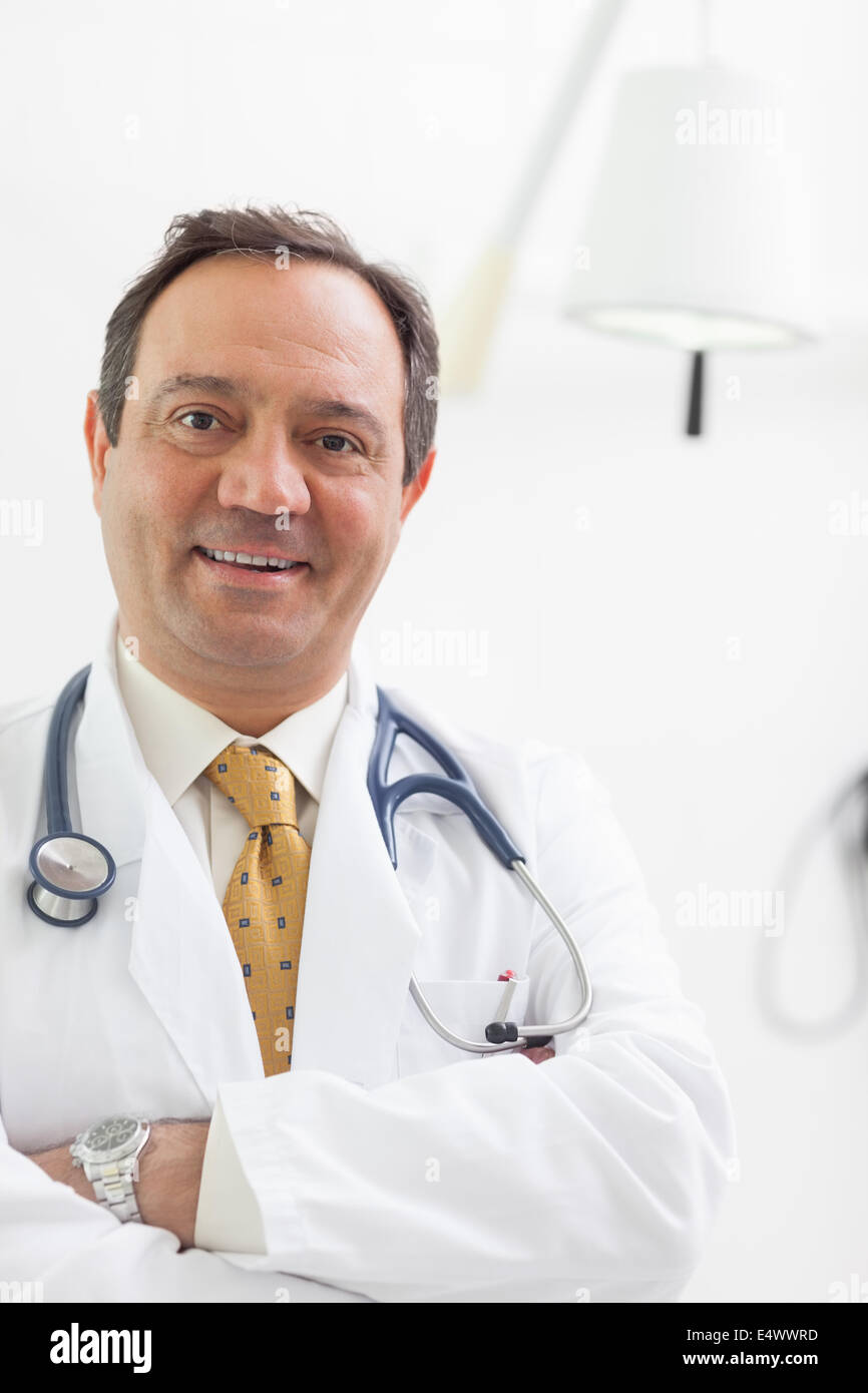Smiling doctor folding his arms Stock Photo - Alamy