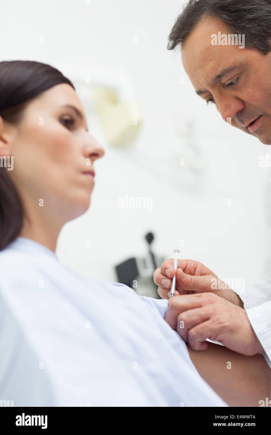 Doctor doing an injection to a patient Stock Photo - Alamy