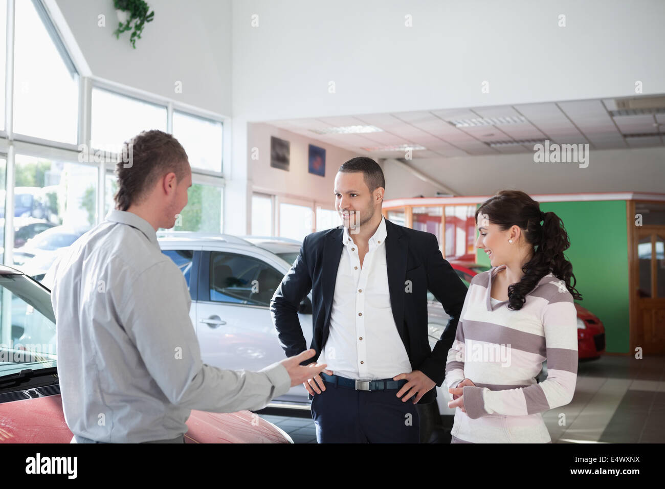 Couple with a car dealer Stock Photo - Alamy